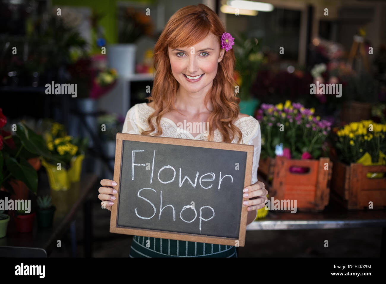 Portrait of female florist holding slate with flower shop sign Stock ...