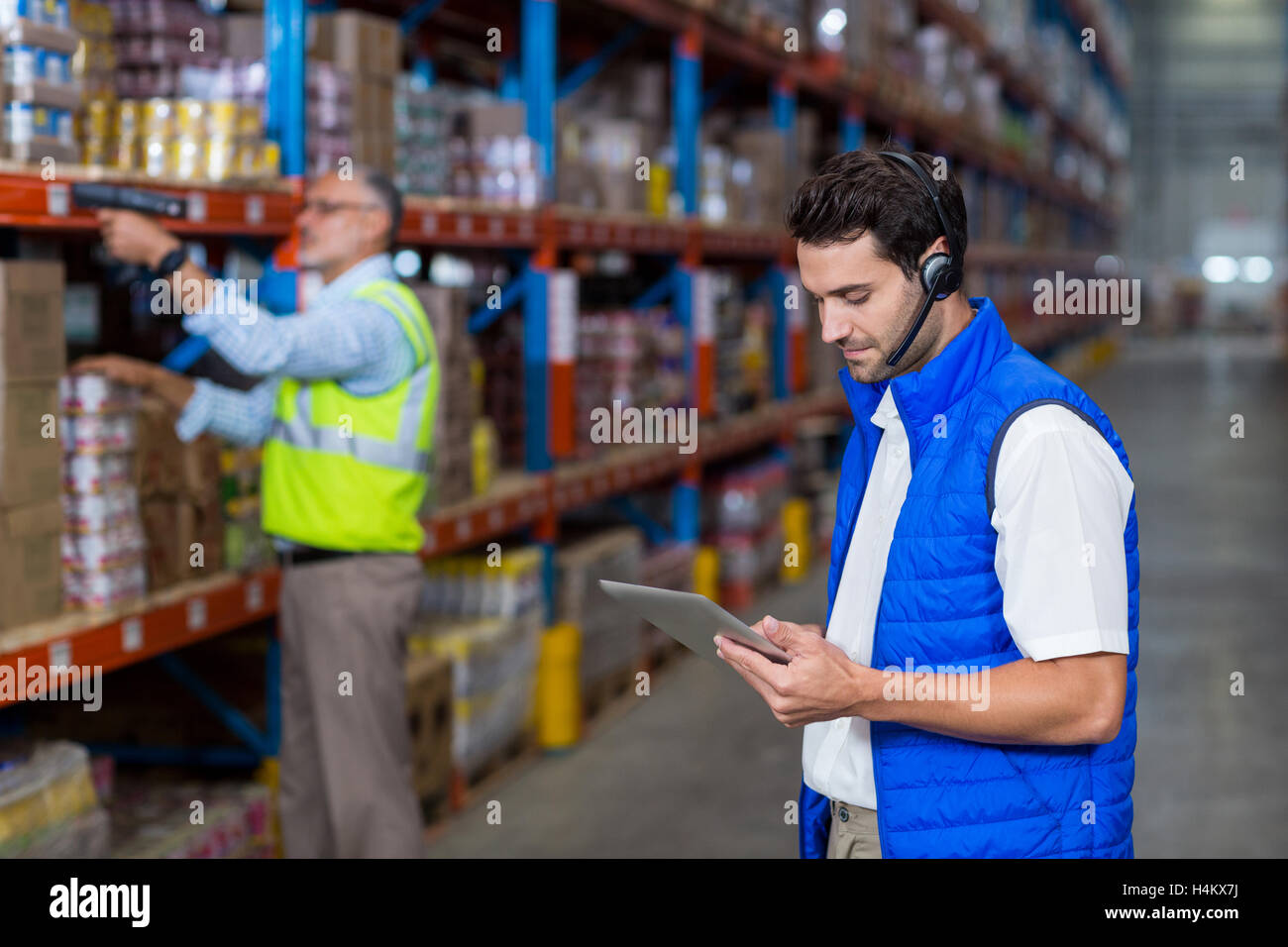 Warehouse worker using digital tablet Stock Photo - Alamy