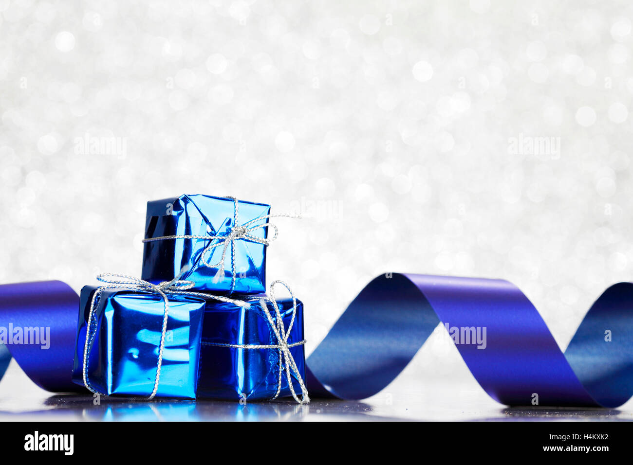 Decorative blue boxes with holiday gifts on shiny glitter background ...