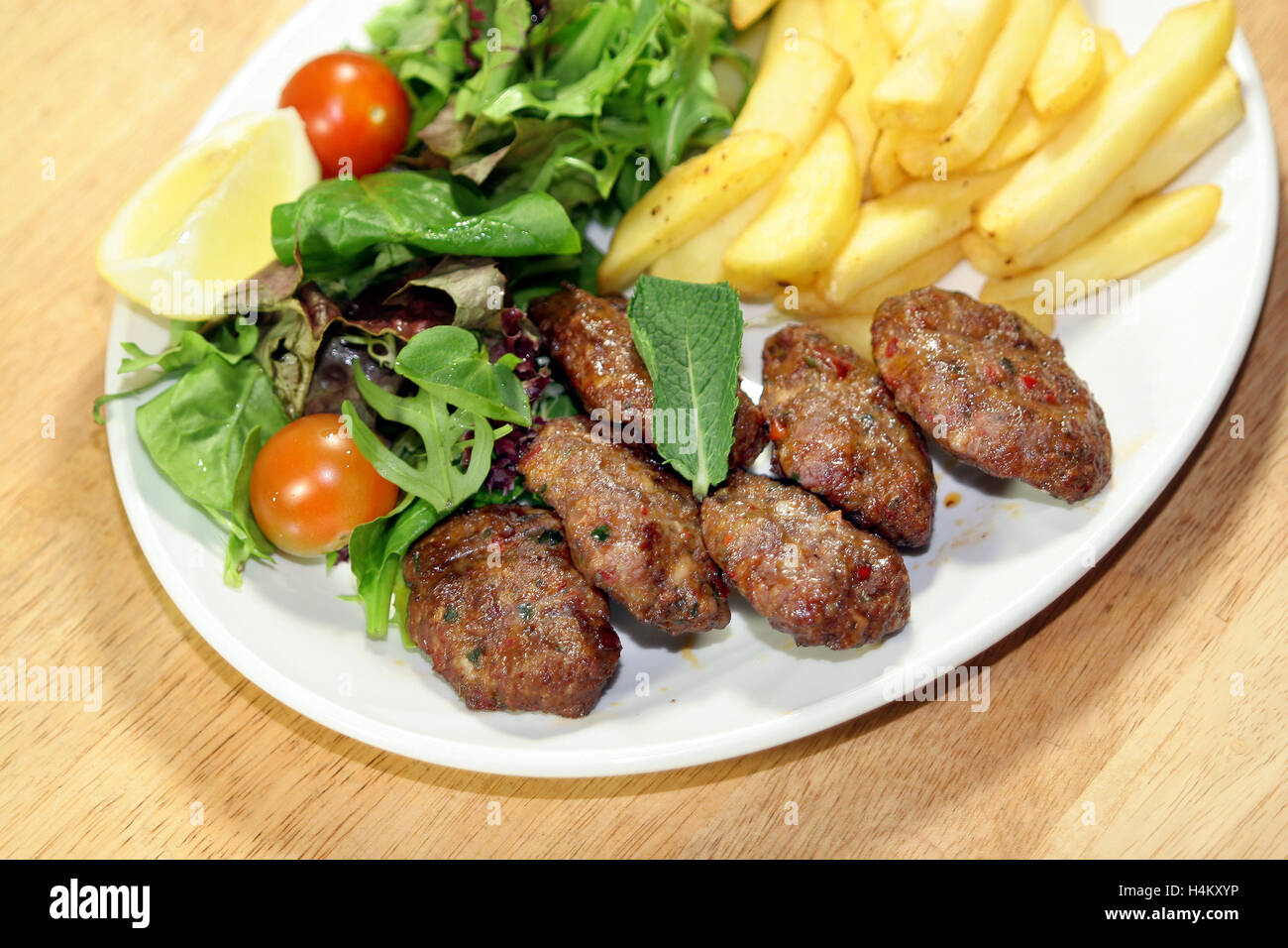 Grilled Meatball served with fries and salad Stock Photo - Alamy