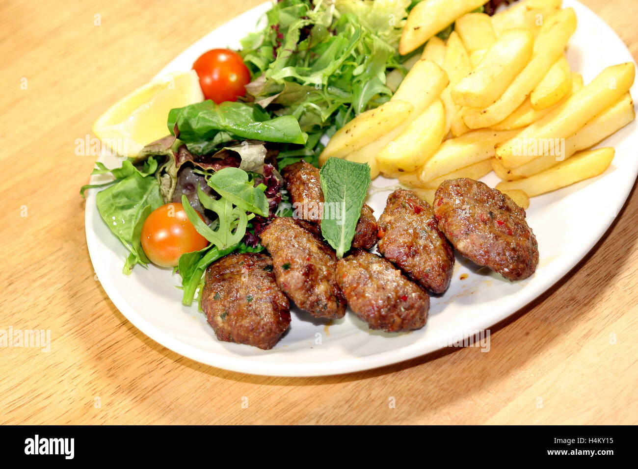Grilled Meatball served with fries and salad Stock Photo - Alamy