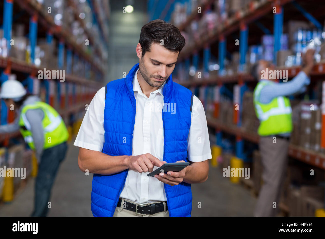 Warehouse worker using calculator Stock Photo - Alamy