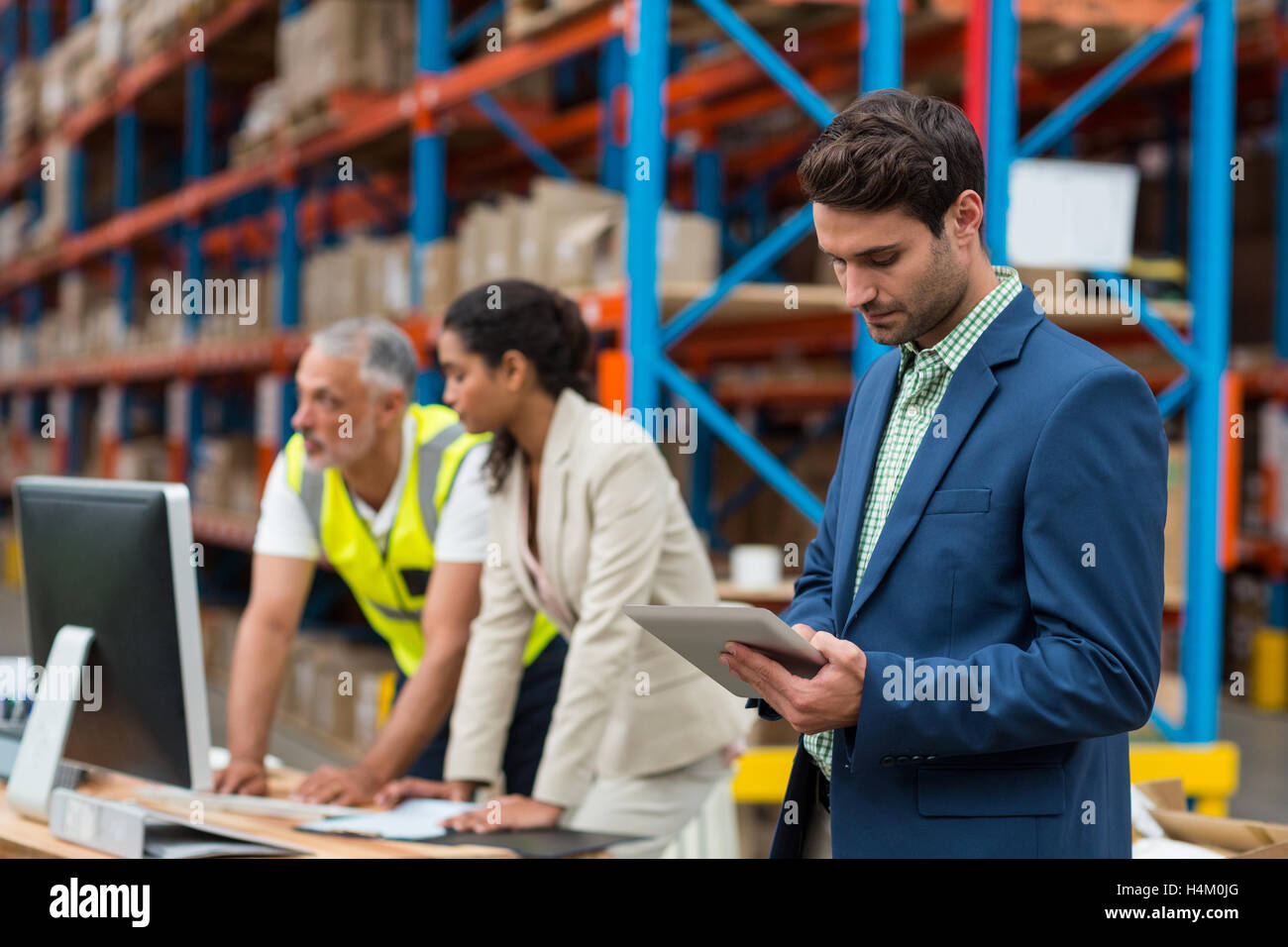Warehouse managers and worker working together Stock Photo - Alamy
