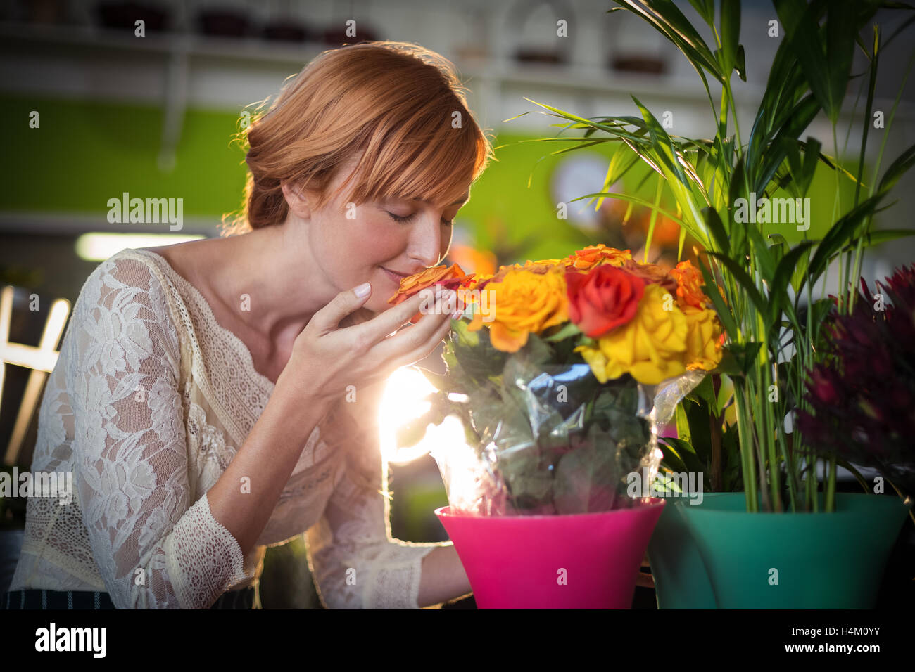 Female florist smelling rose flowers Stock Photo - Alamy