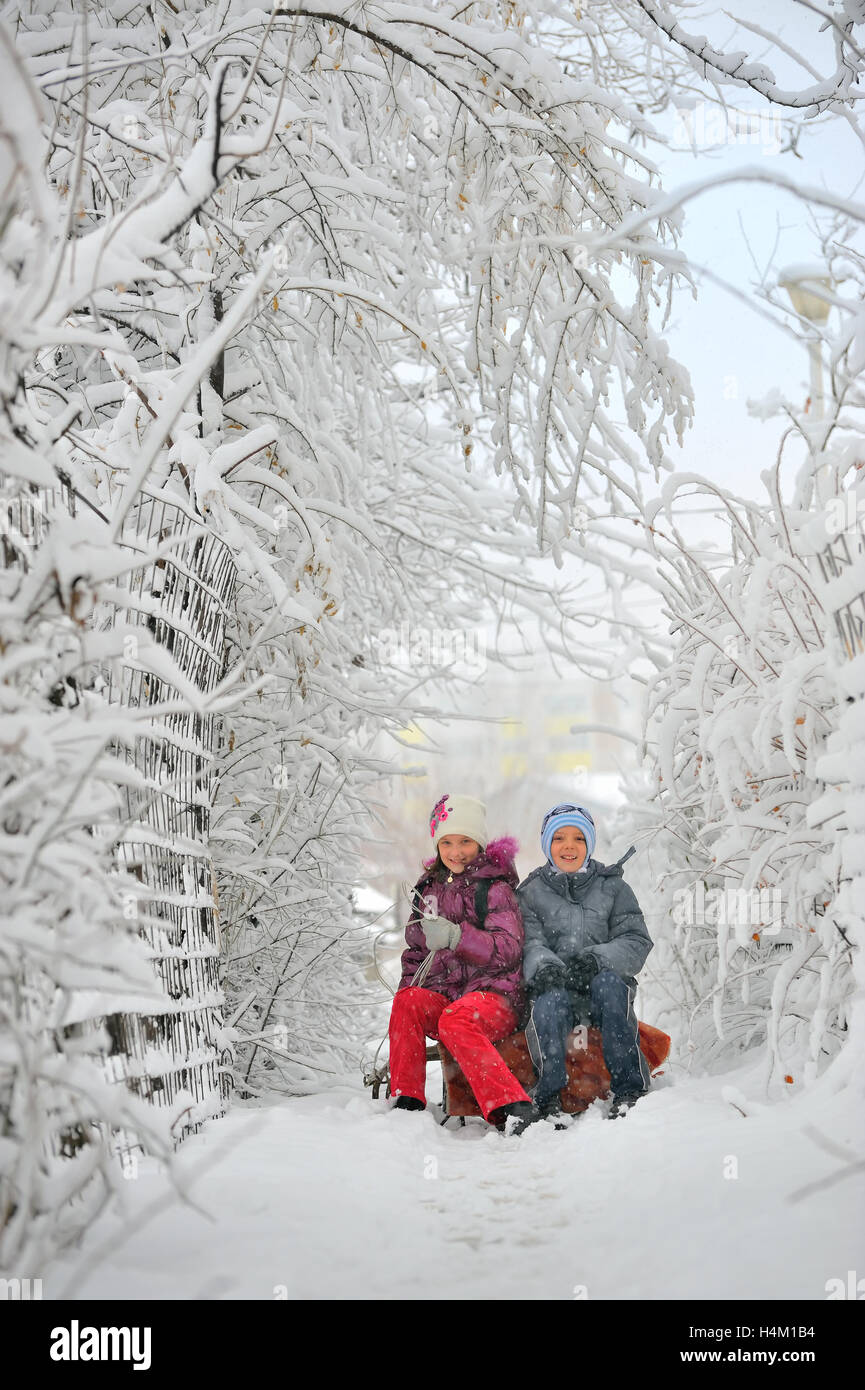Two kids sliding with sledding in the snow Stock Photo - Alamy