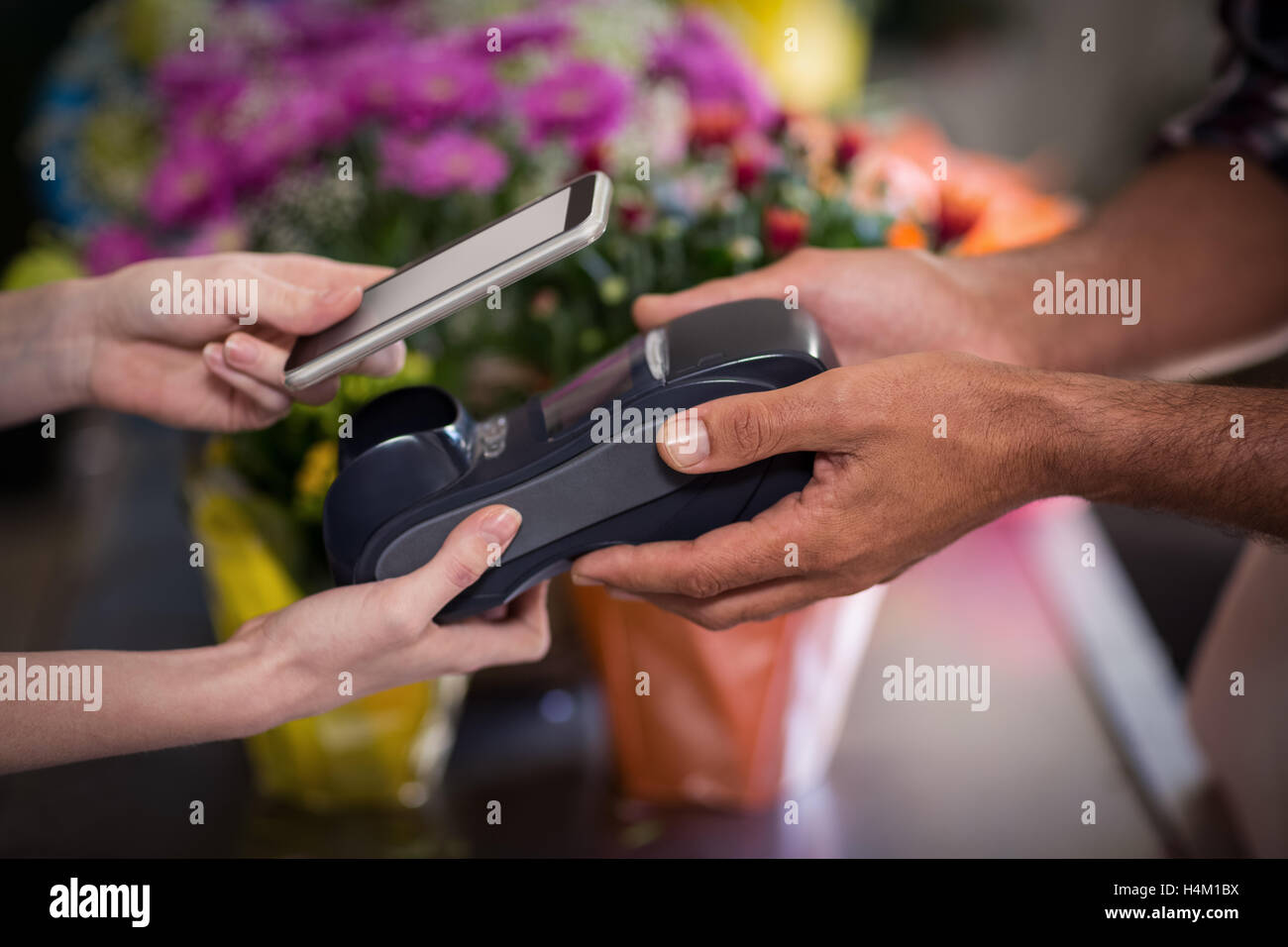 Hand of customer making payment through smartphone Stock Photo - Alamy