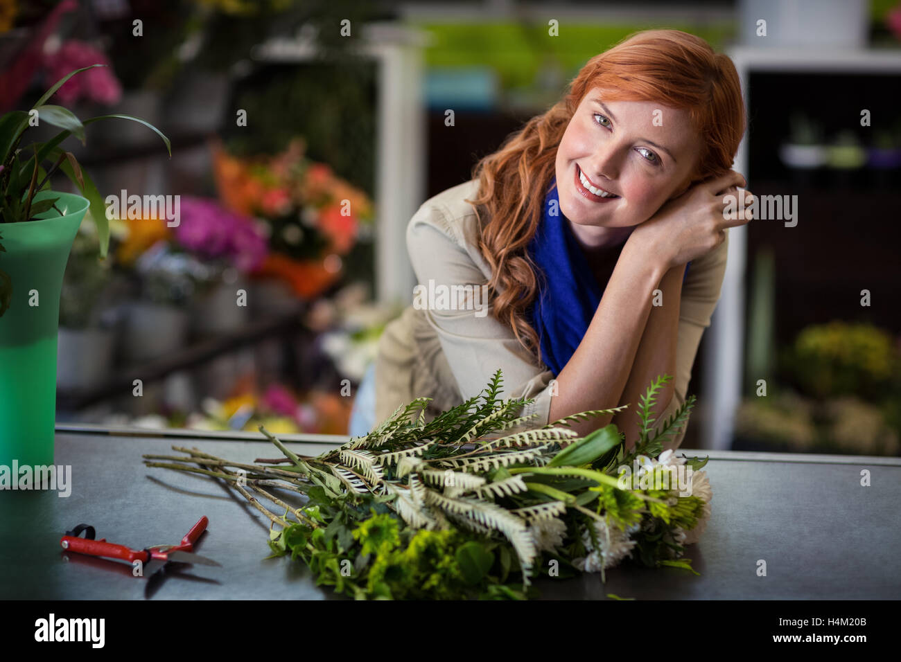 Happy female florist leaning in flower shop Stock Photo - Alamy