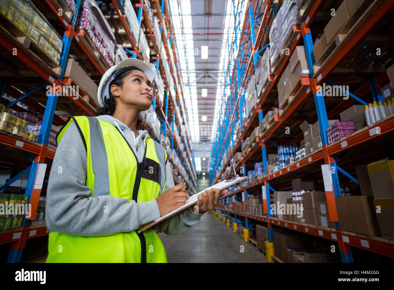 Female warehouse worker looking at packages Stock Photo - Alamy