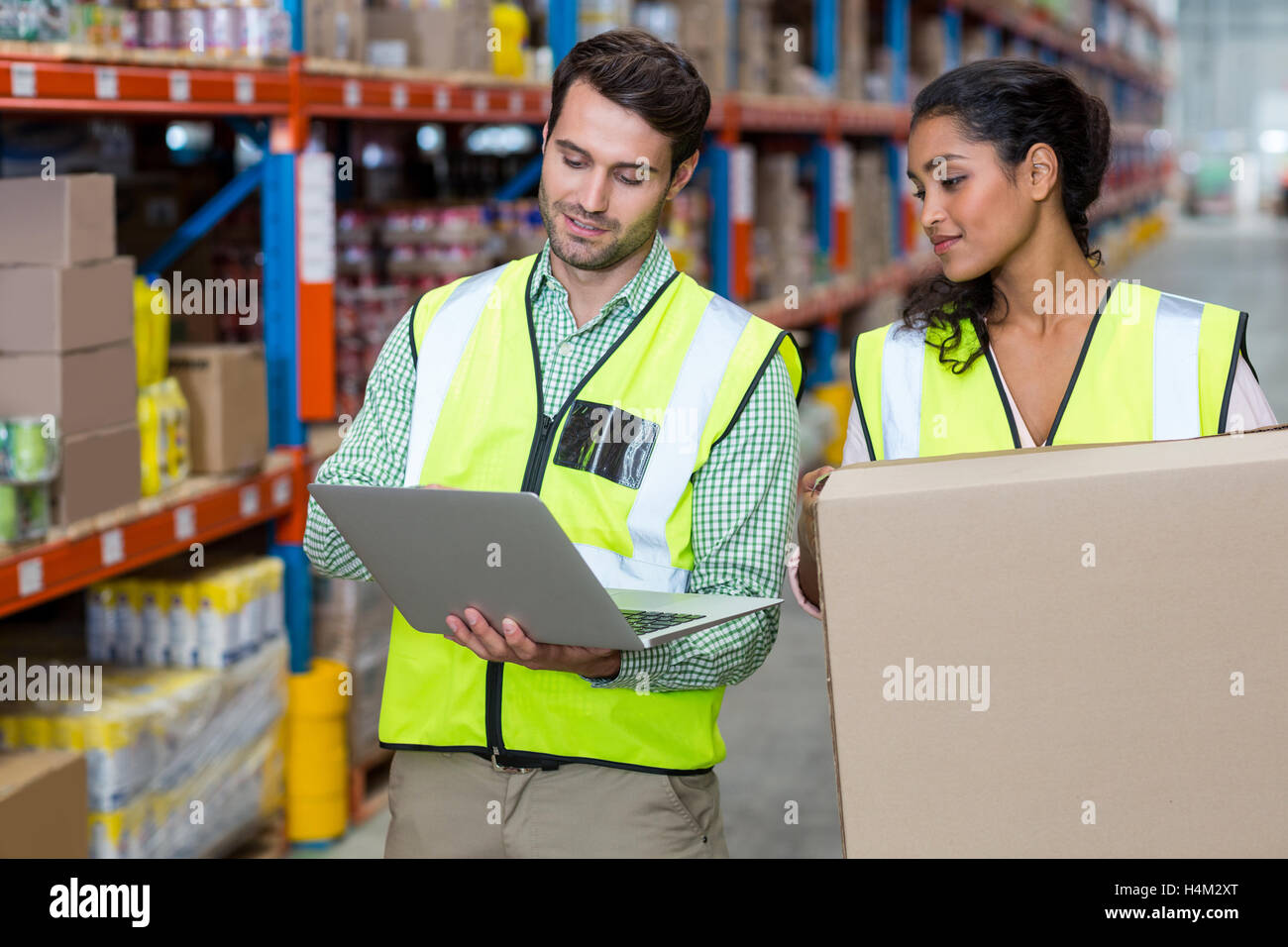 Warehouse workers working on laptop Stock Photo - Alamy