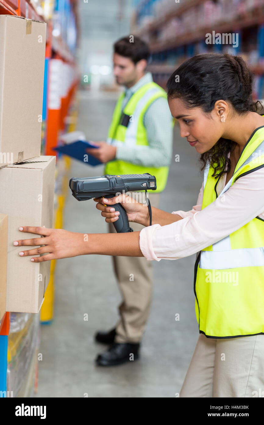 Female warehouse worker scanning box Stock Photo - Alamy
