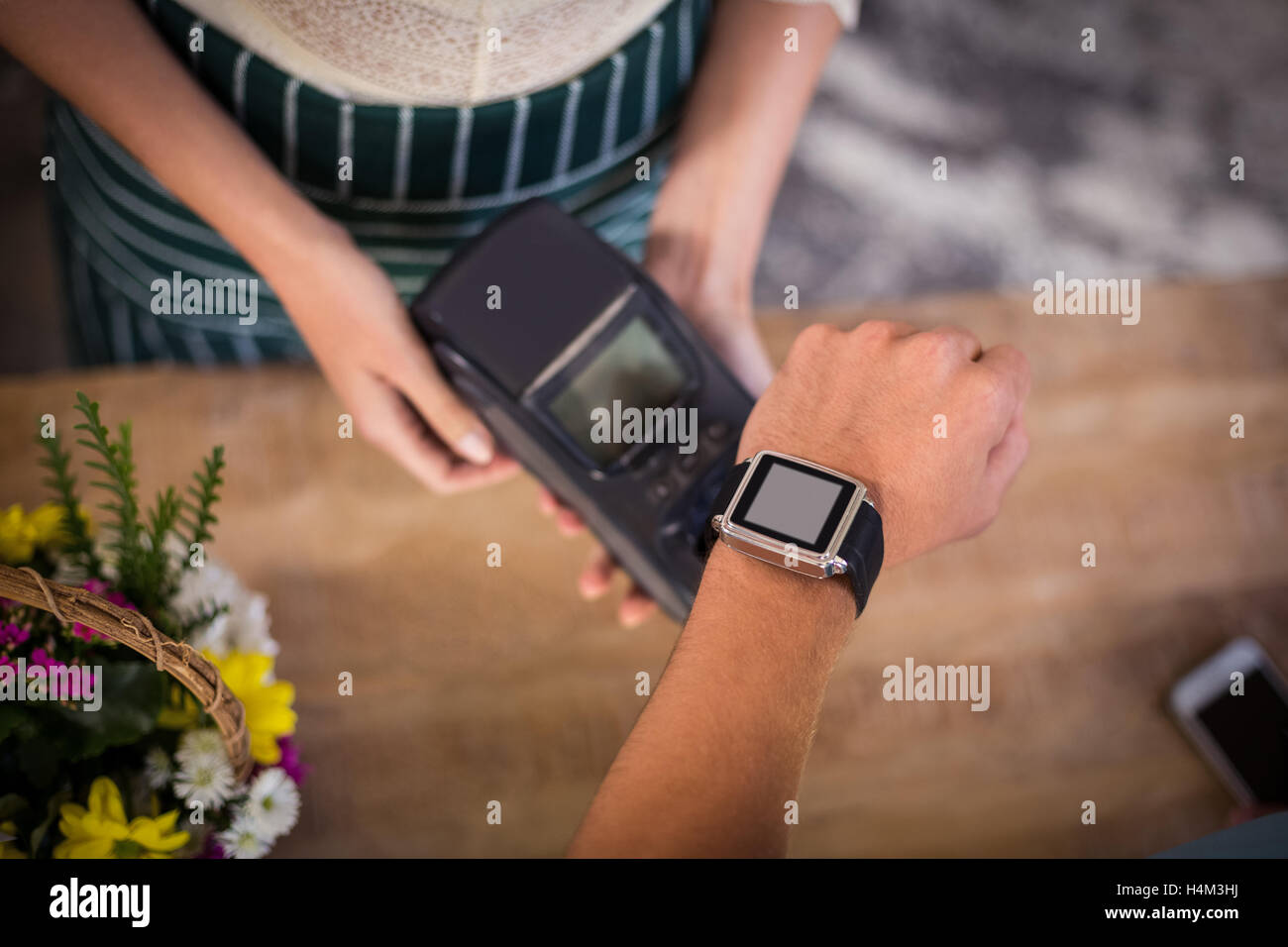 Hand of customer making payment through smartwatch Stock Photo - Alamy