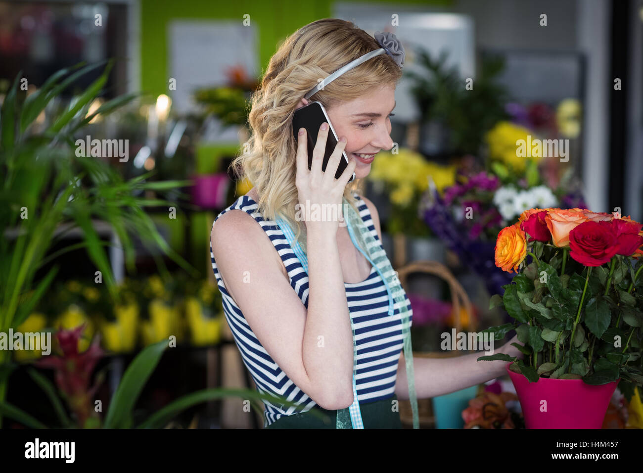 Female florist talking on mobile phone Stock Photo - Alamy