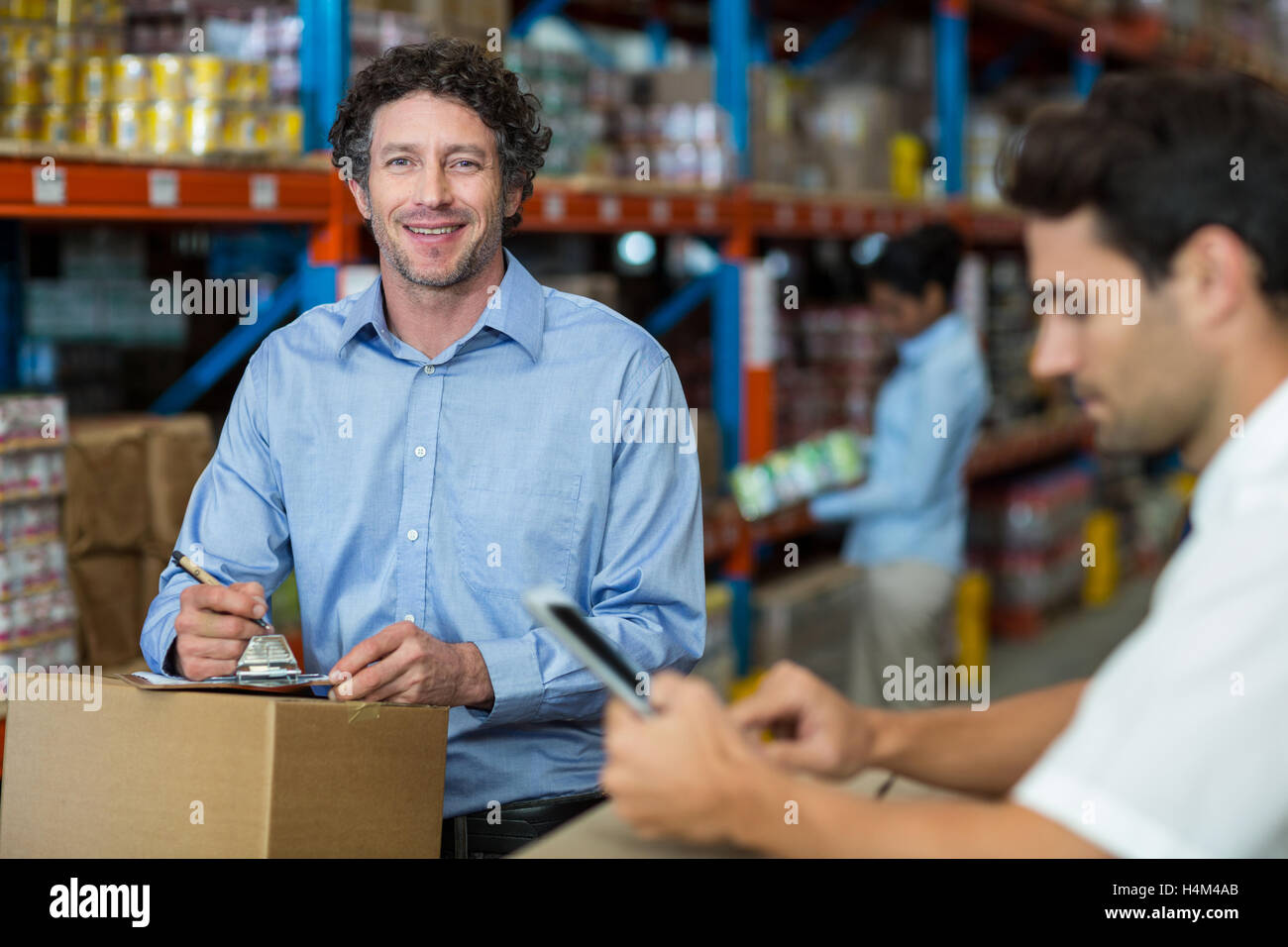 Two warehouse workers working together Stock Photo - Alamy