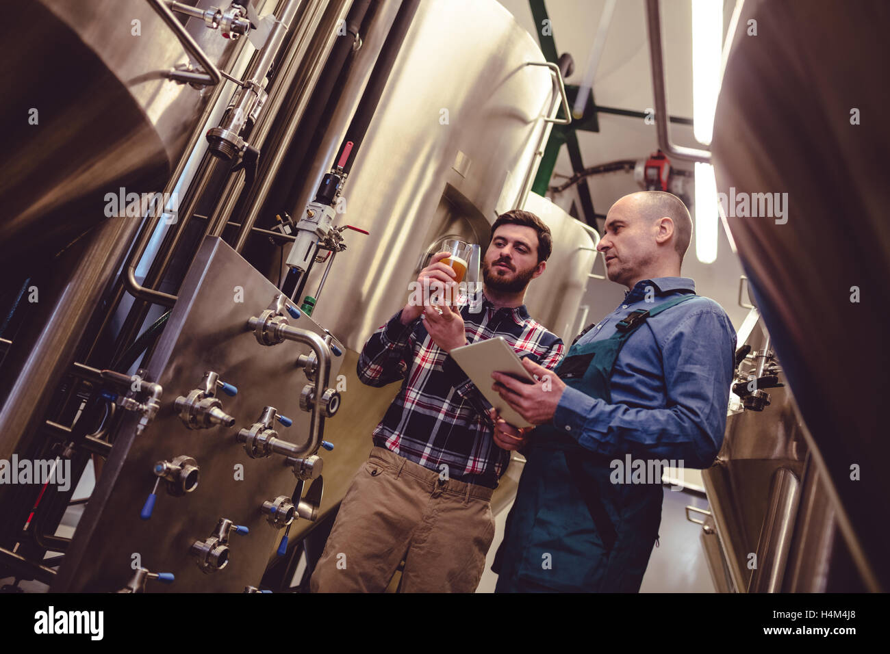 Worker and owner discussing over beer in containe Stock Photo - Alamy
