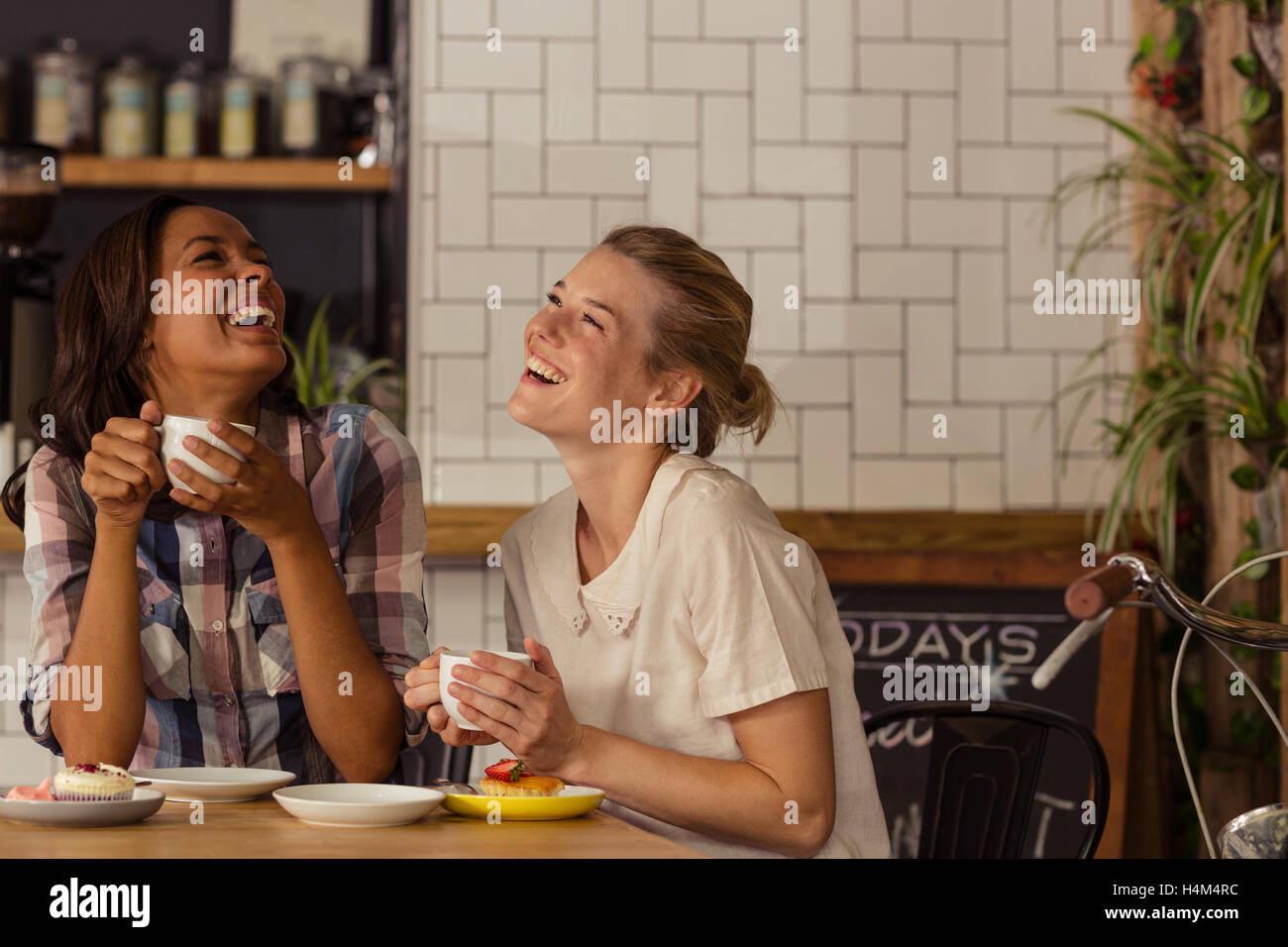 Female friends having fun while having coffee Stock Photo - Alamy
