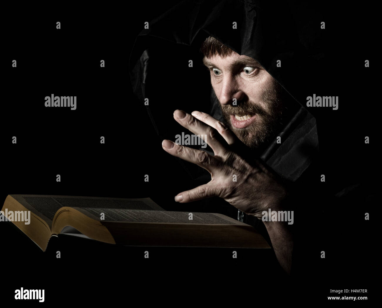 necromancer casts spells from thick ancient book by candlelight on a ...