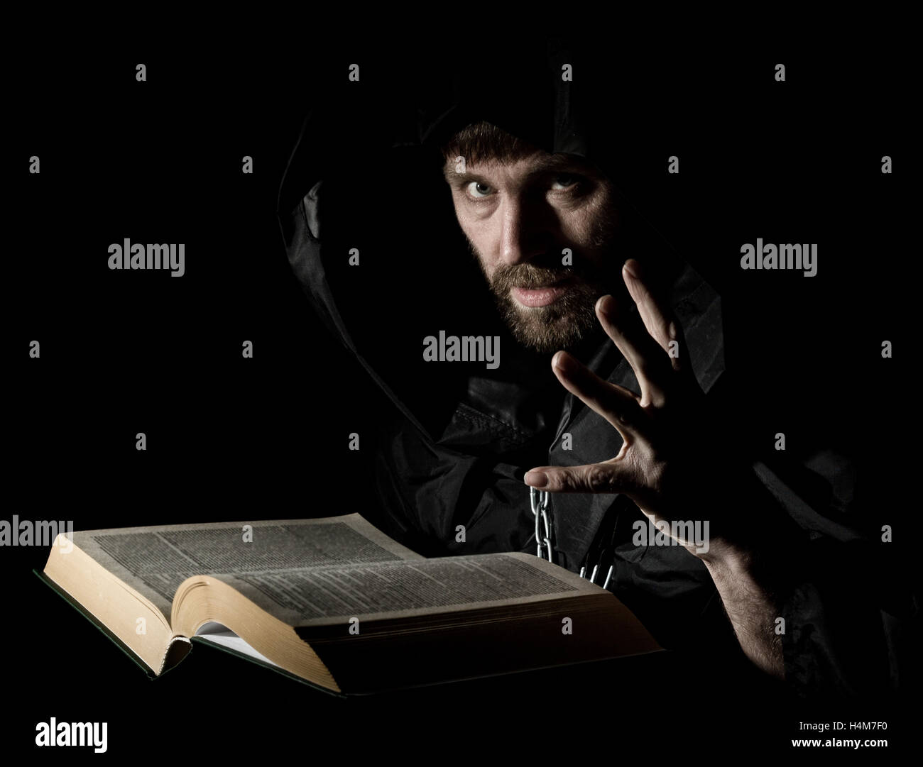 necromancer casts spells from thick ancient book by candlelight on a ...