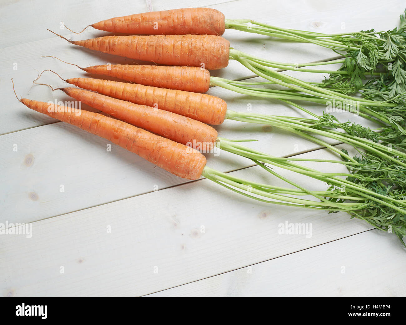 Raw whole carrot on wooden surface table Stock Photo - Alamy