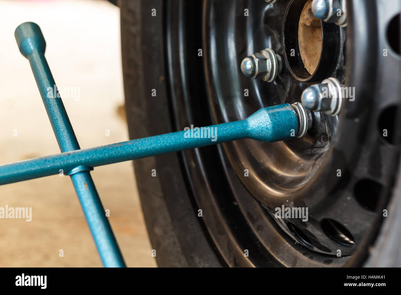 Changing tire with wheel wrench Stock Photo - Alamy