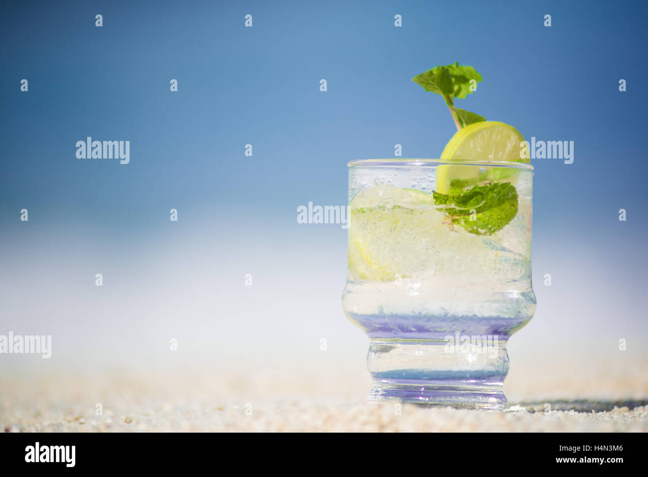 a glass of lemonade on sandy beach Stock Photo - Alamy