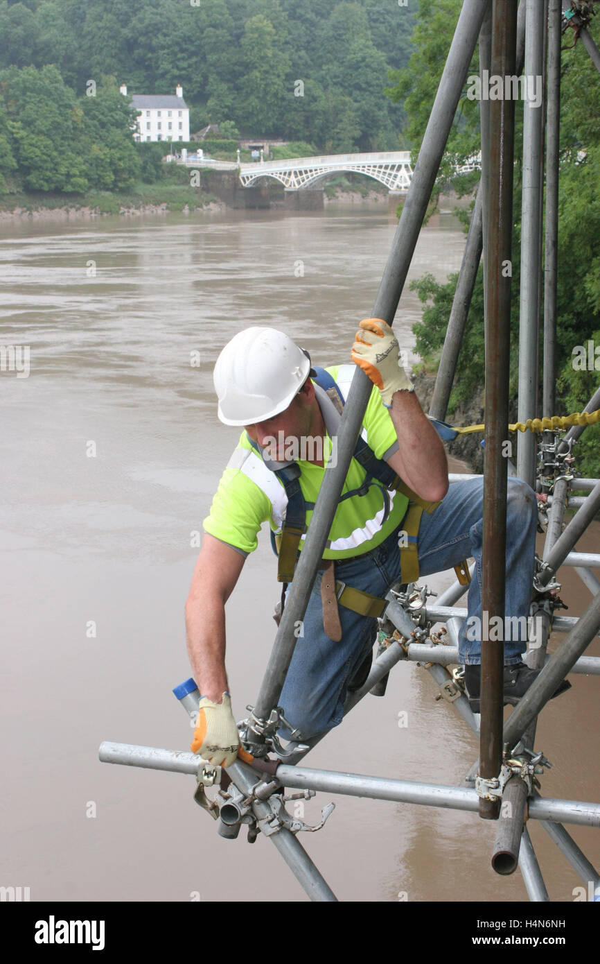 Chepstow Castle. A scaffolder assembles traditional scaffolding high ...