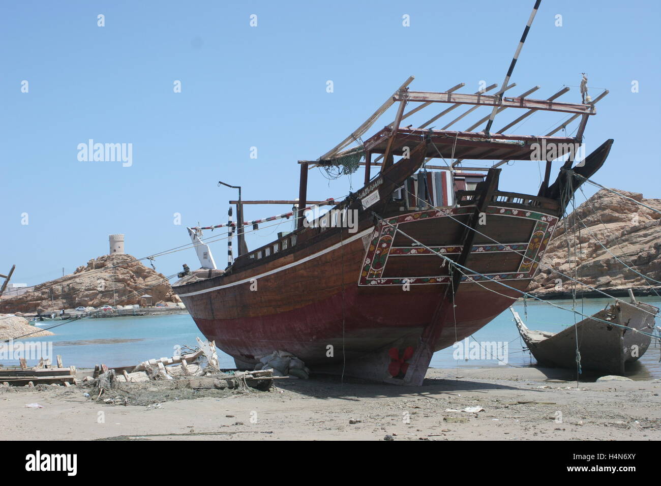 A traditional timber fishing dhow on the beach at Sur in Oman, on the ...