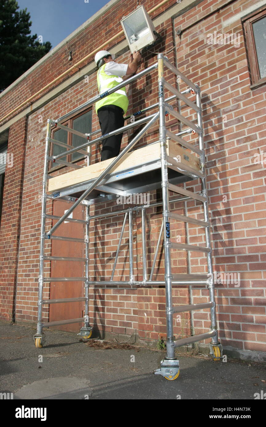 A workman inspects an exterior floodlight using a Boss narrow-width ...