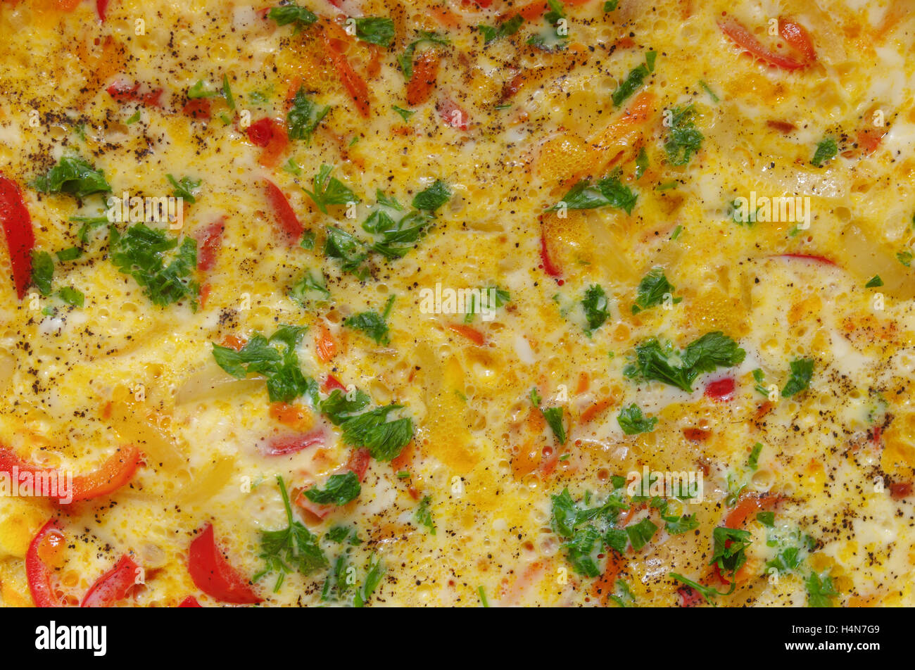Summer food background - omelet with pieces of bell pepper, onions and ...