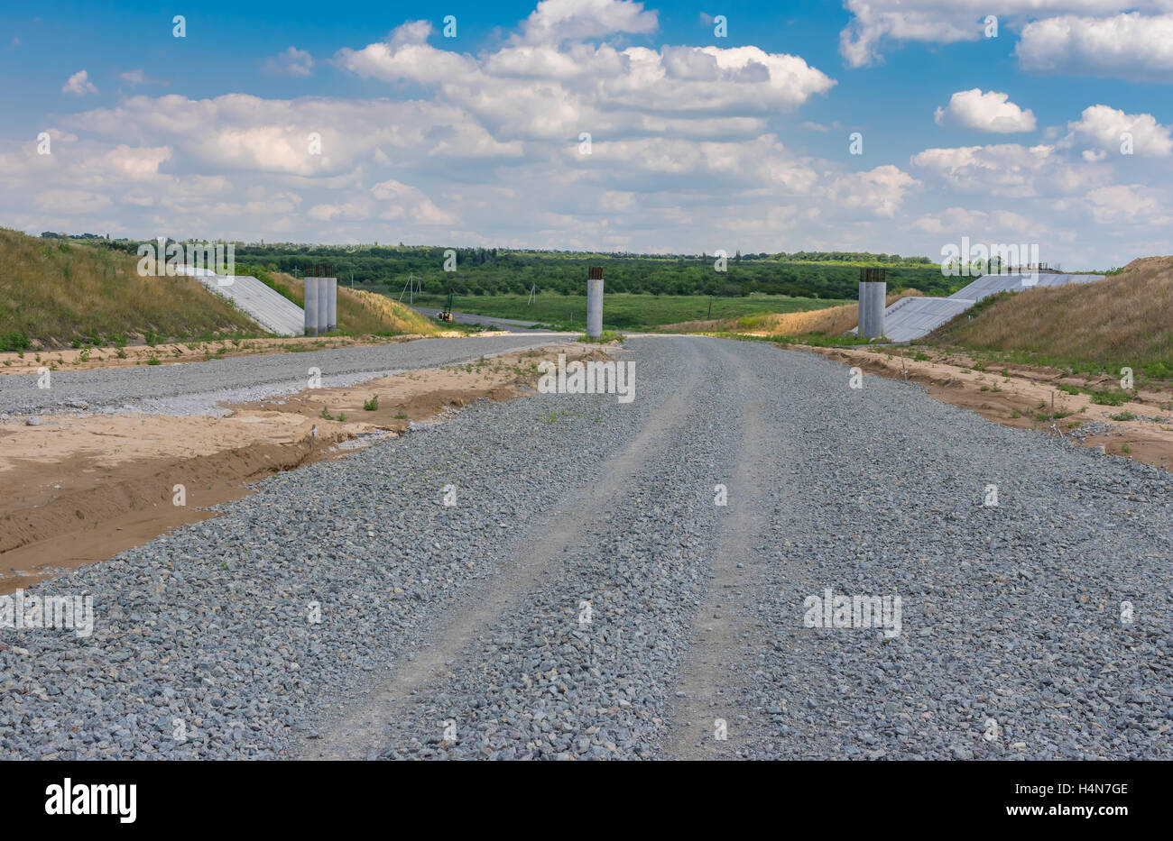 Summer landscape in Ukraine with stone layer of unfinished highway near ...