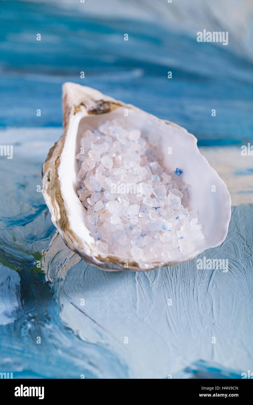 Blue persian sea salt in sea shell oyster on blue abstract painted ...