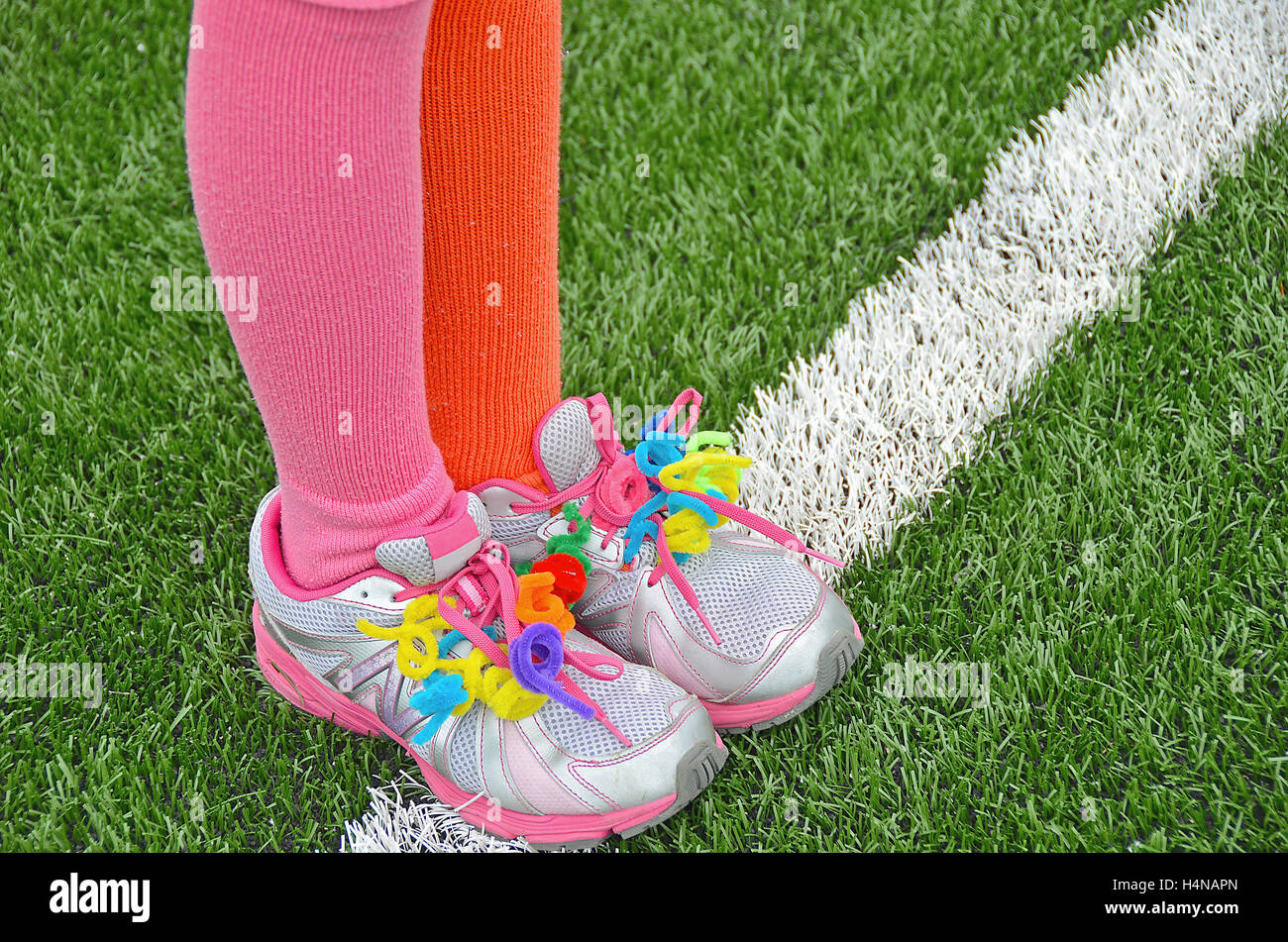 colorful pipe cleaner shoe laces on sport shoe on football field Stock ...