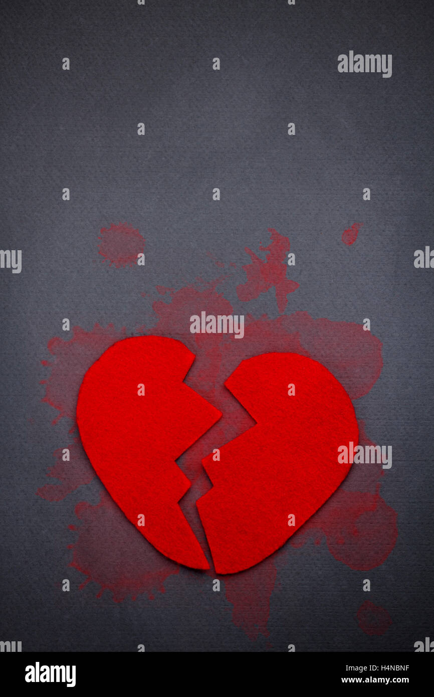 Red broken heart on grey background Stock Photo - Alamy