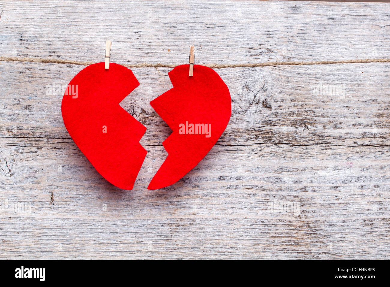 Broken heart hanging on rope Stock Photo - Alamy