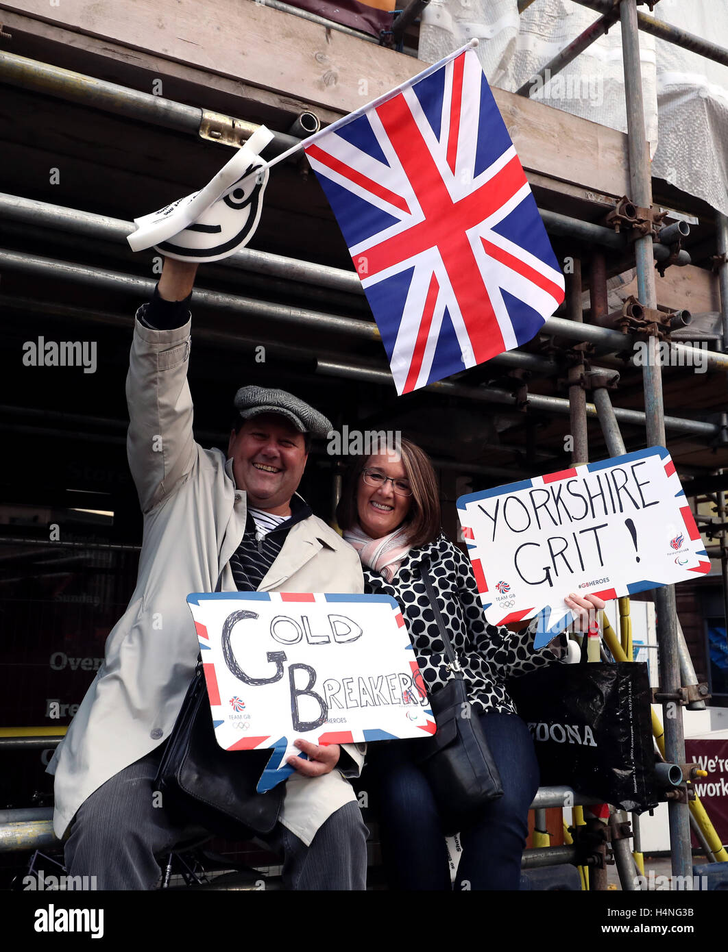 Fans line the route with signs and flags during the Olympic and ...