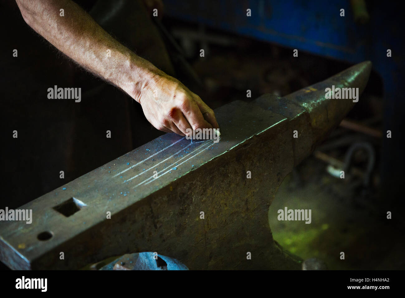 A blacksmith draws a design onto anvil with chalk Stock Photo - Alamy
