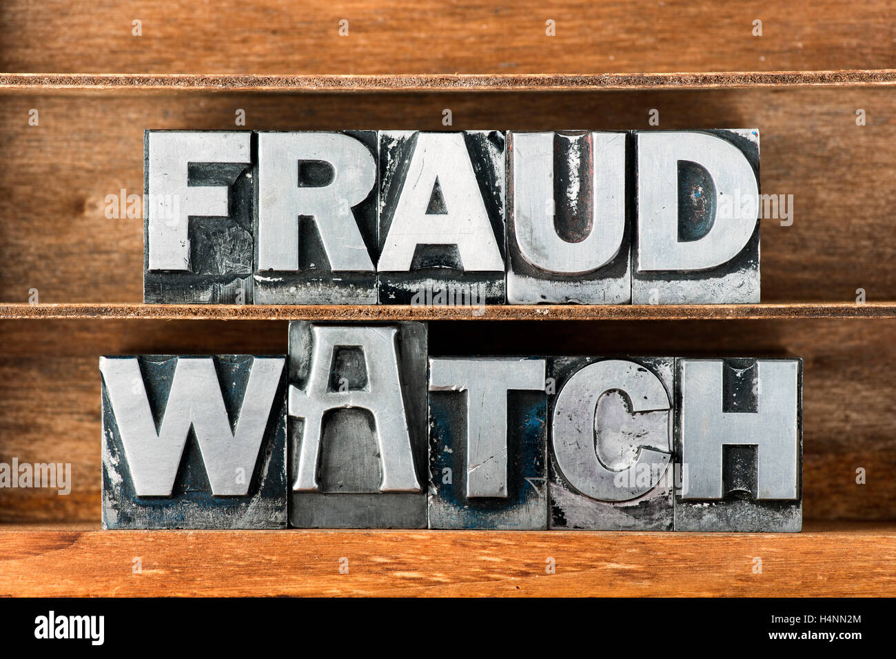 fraud watch phrase made from metallic letterpress type on wooden tray ...