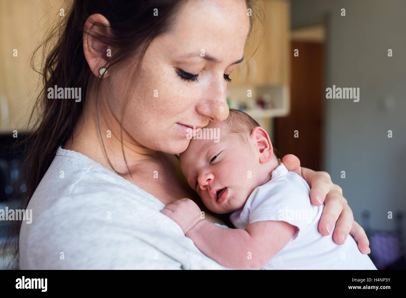 Young mother in kitchen holding her son in her arms Stock Photo - Alamy