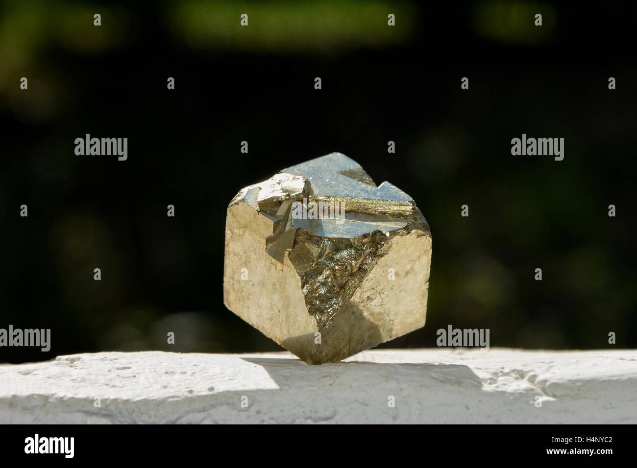 Pyrite cube on white wall with dark background Stock Photo - Alamy