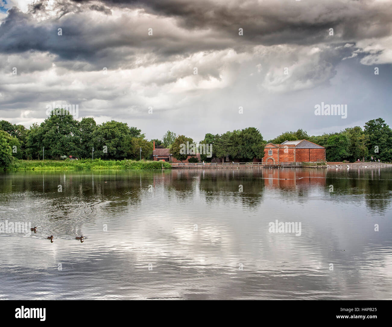 Rolling moody clouds reflections in lake at Rufford Country Park ...