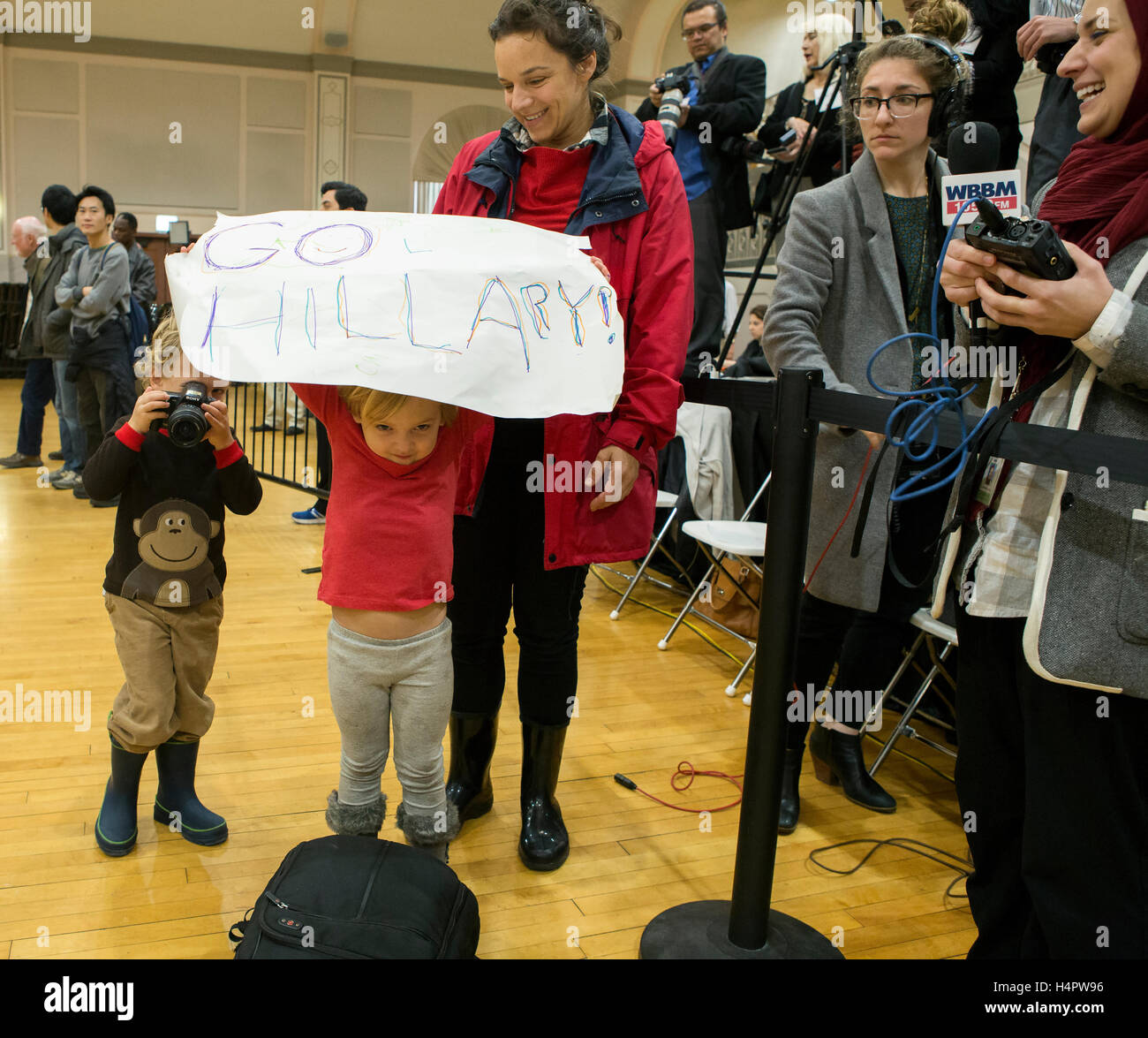 A child holds up a sign saying "Go Hillary" while her brother holds up ...