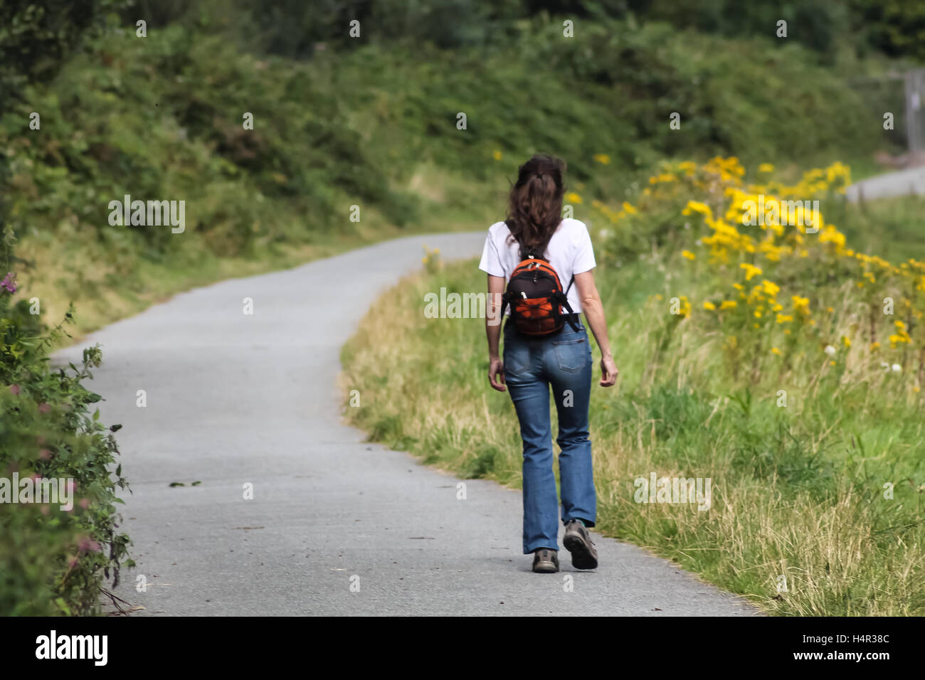 Girl walking on a country path Stock Photo - Alamy