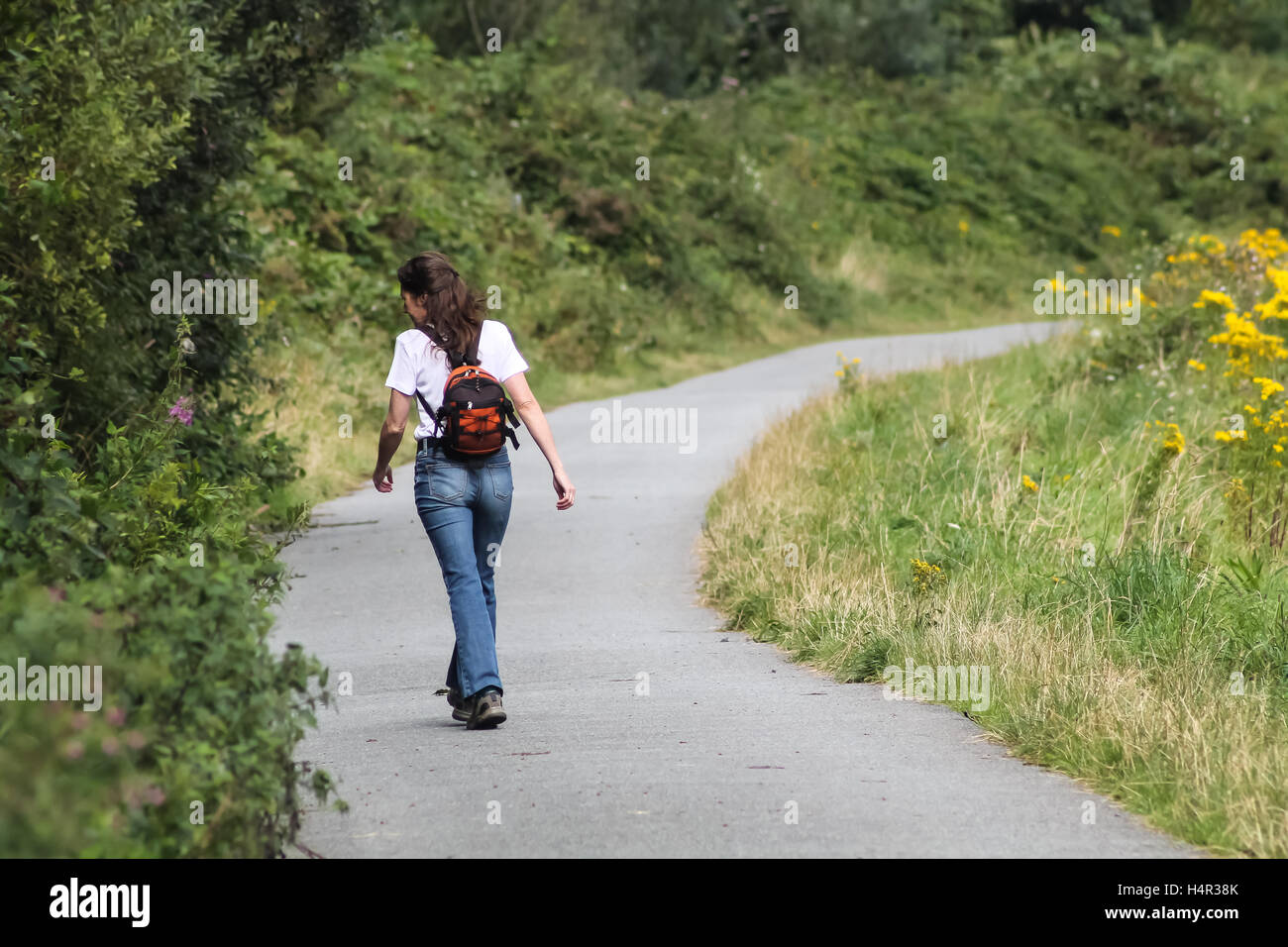 Girl walking on a country path Stock Photo - Alamy