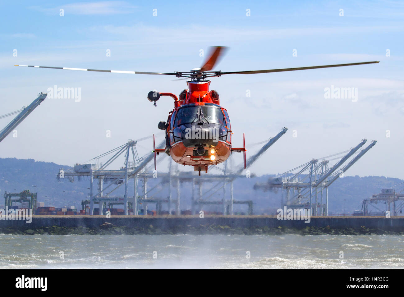 United States Coast Guard MH-65 Dolphin hovers over the waters of San ...