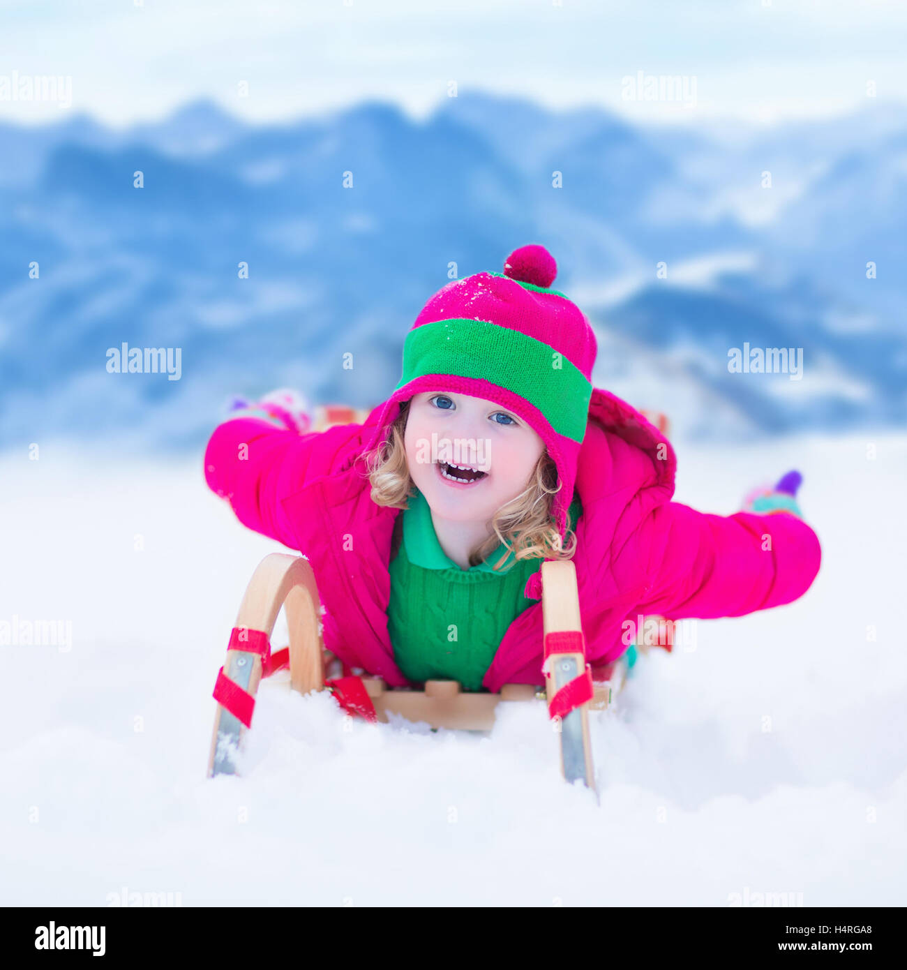 Little girl enjoying a sleigh ride. Child sledding. Toddler kid riding ...