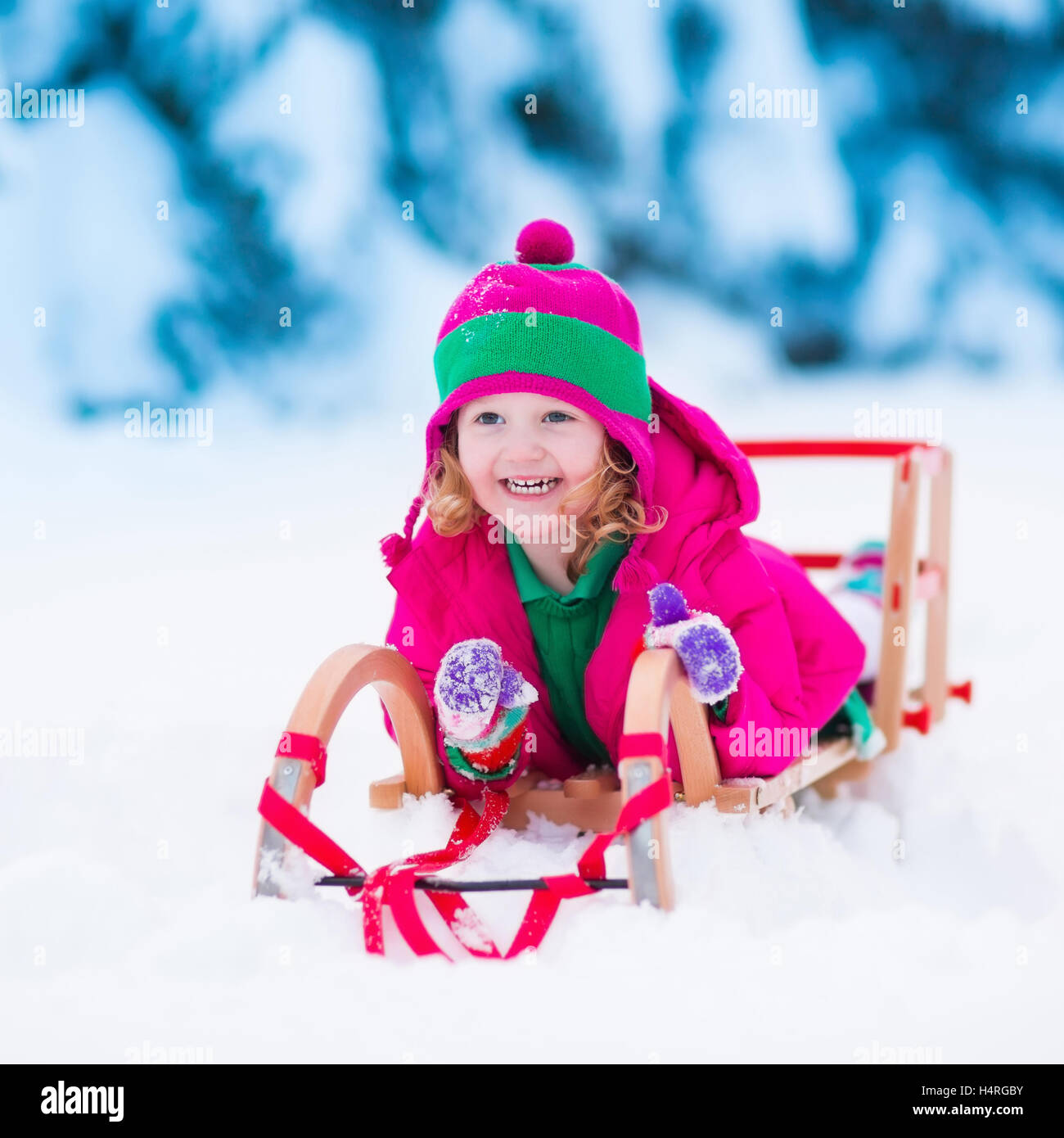 Little girl enjoying a sleigh ride. Child sledding. Toddler kid riding ...