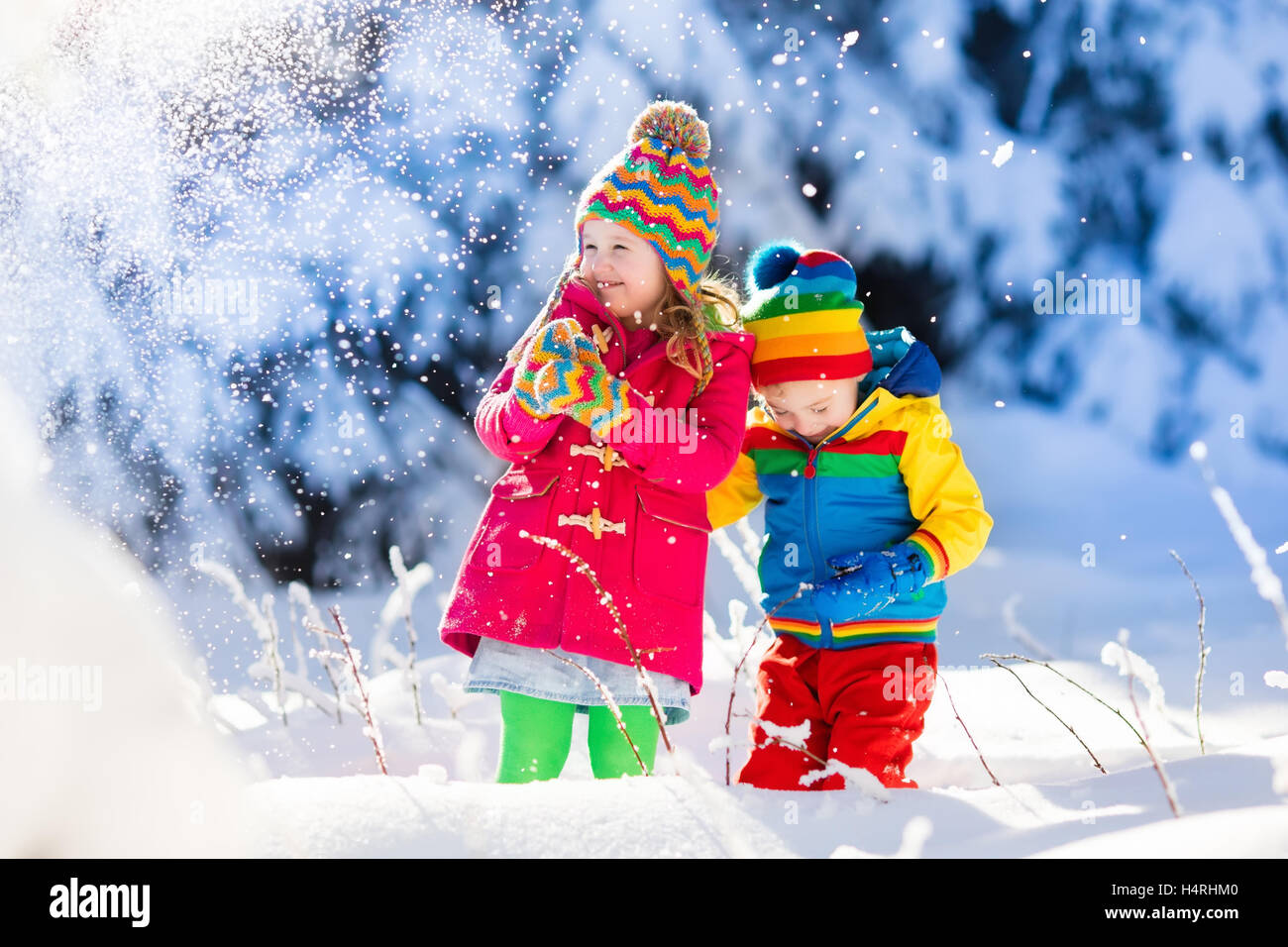 Children play in snowy forest. Toddler kids outdoors in winter. Friends ...
