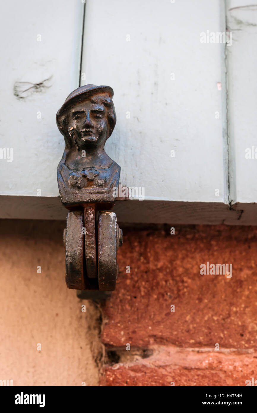 Closeup on antique metal window shutter holder in shape of woman's head ...