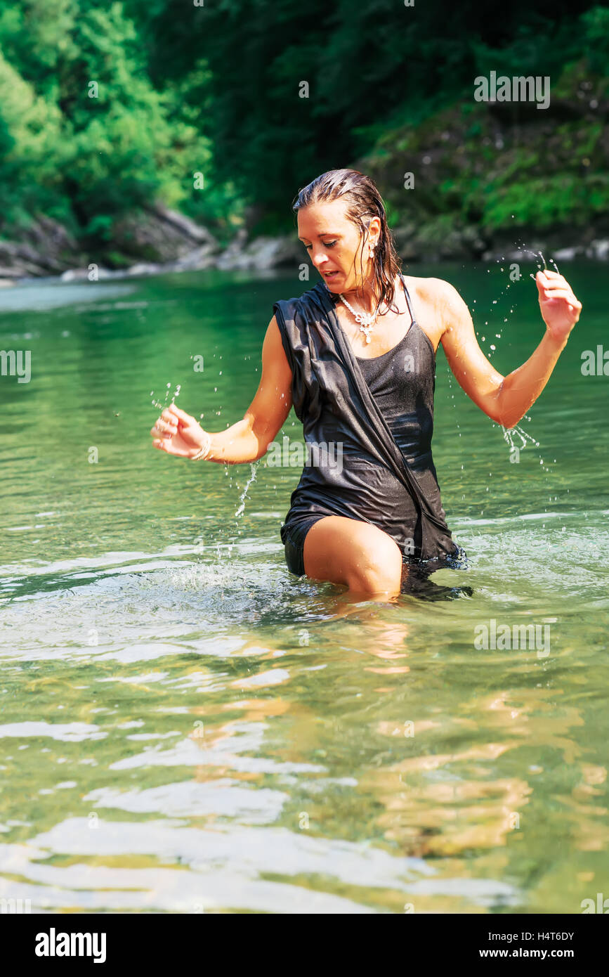 Beautiful woman in black dress in a river Stock Photo - Alamy
