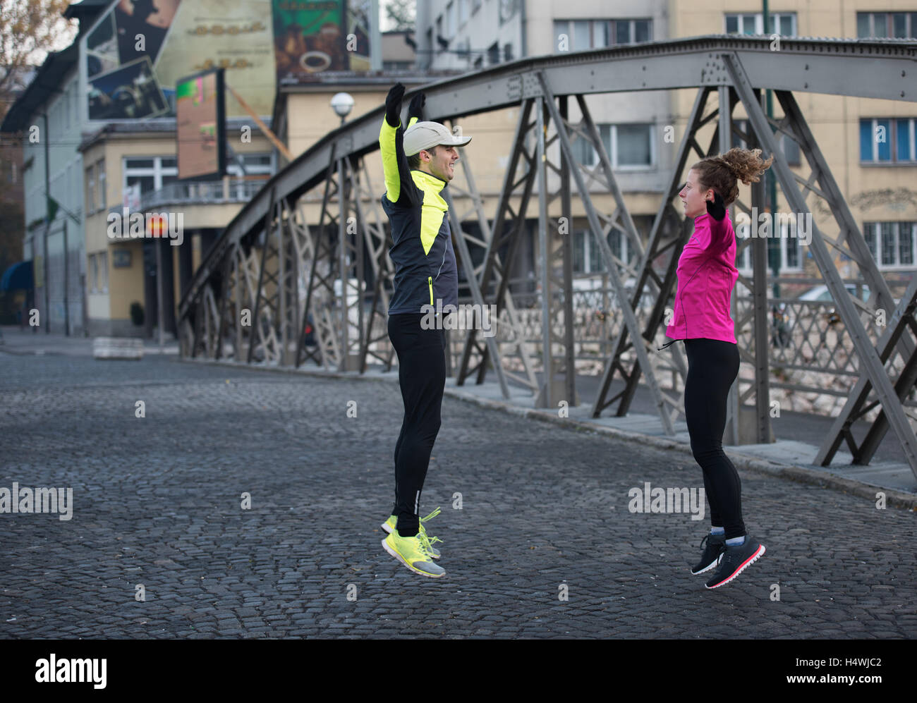 jogging couple warming up and stretching before morning running in the ...
