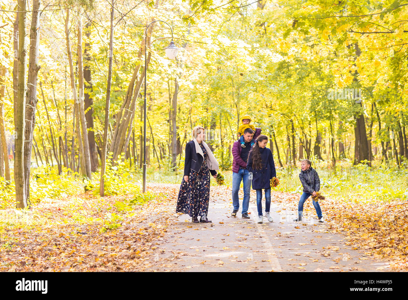 Happy young family spending time together outside in autumn nature ...